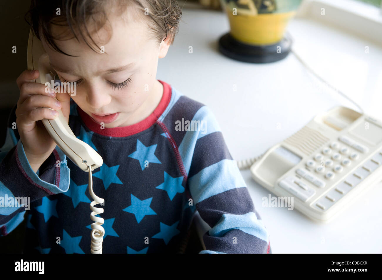 6 year old english boy using a landline phone at his grandparents home ...