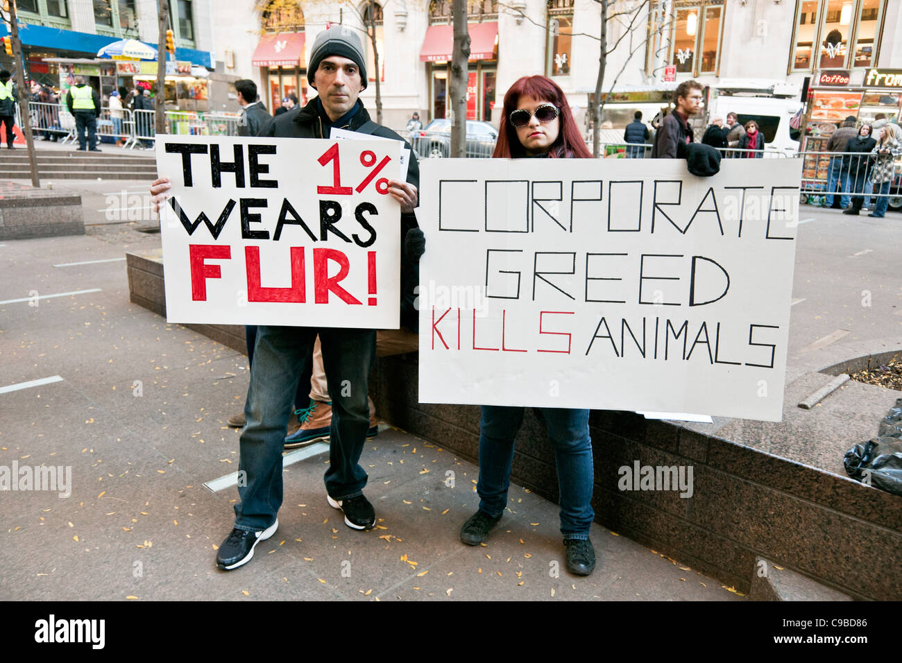 two serious young animal rights activists hold up signs in Zuccotti ...