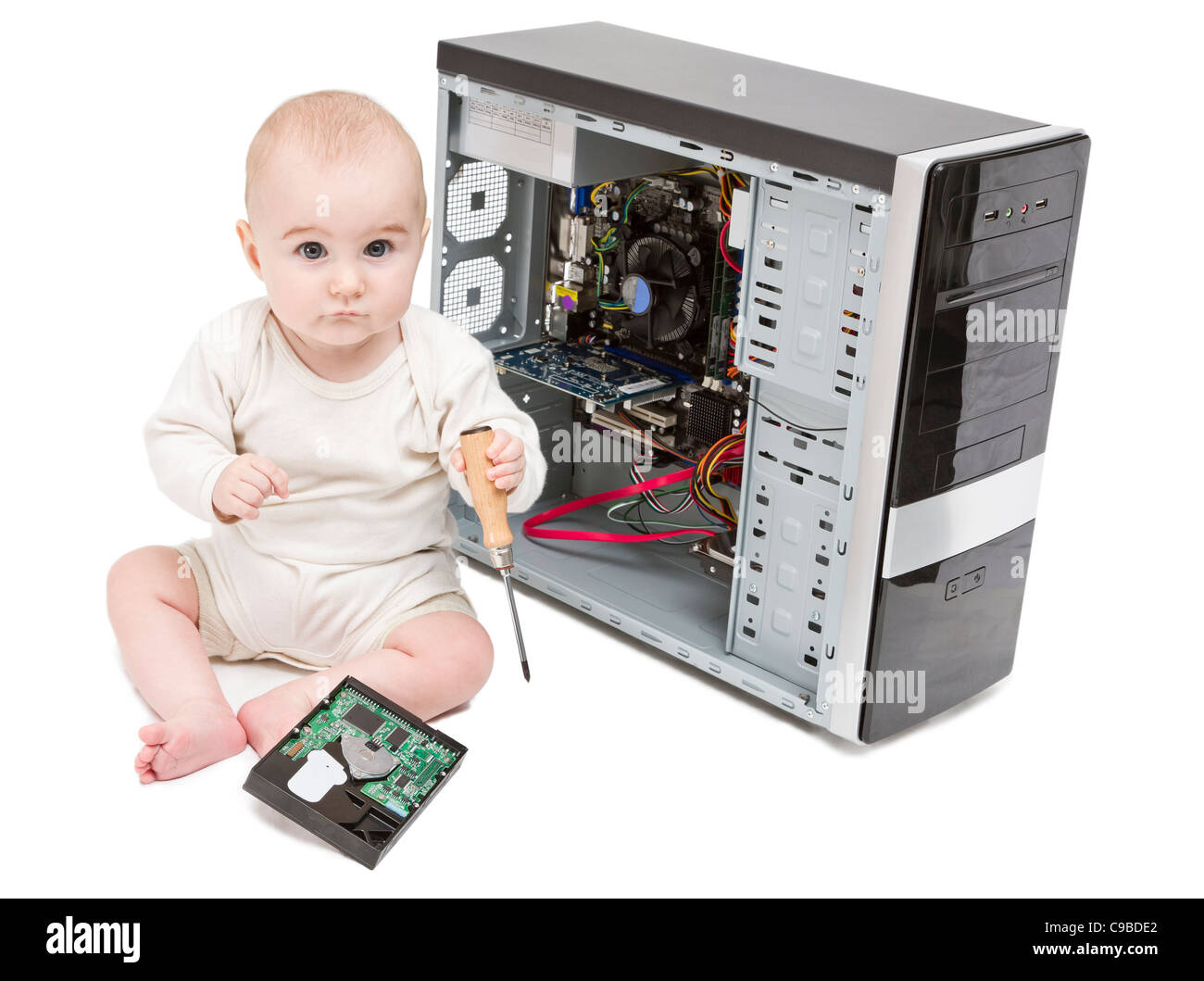 young child with screwdriver in hand working on open computer in white ...