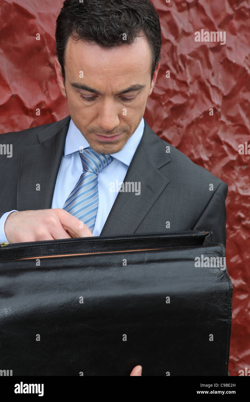 Businessman looking in his briefcase Stock Photo - Alamy