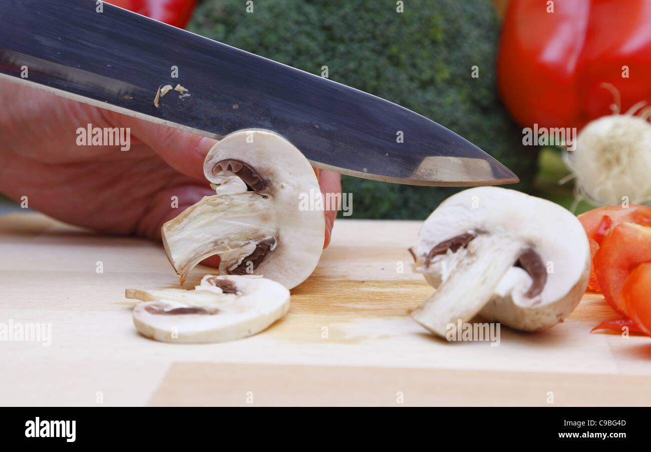 Detail of a knife cutting mushrooms Stock Photo - Alamy