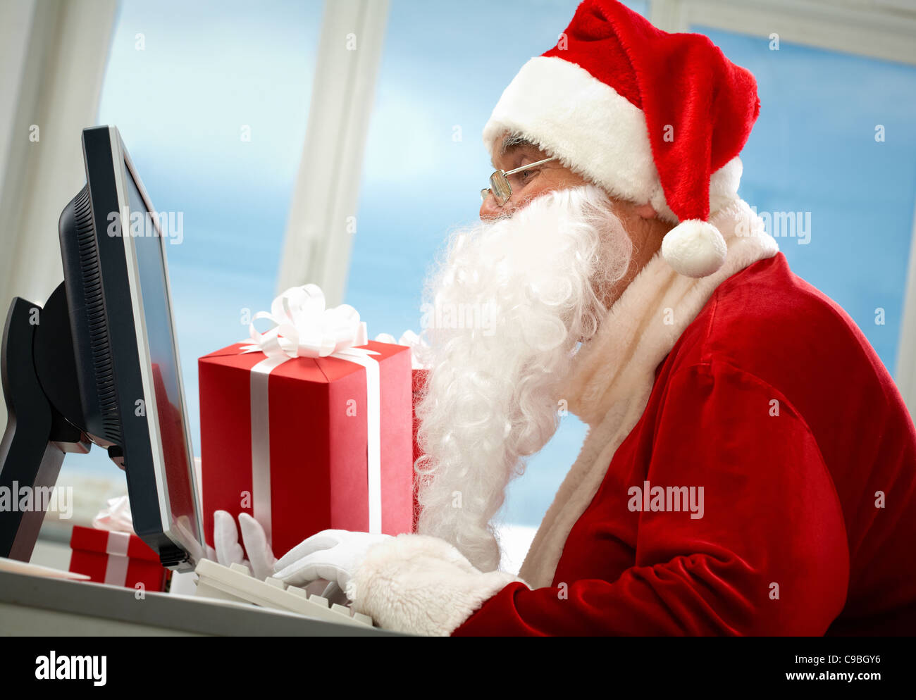 Portrait of Santa Claus in front of computer monitor with gifts Stock ...