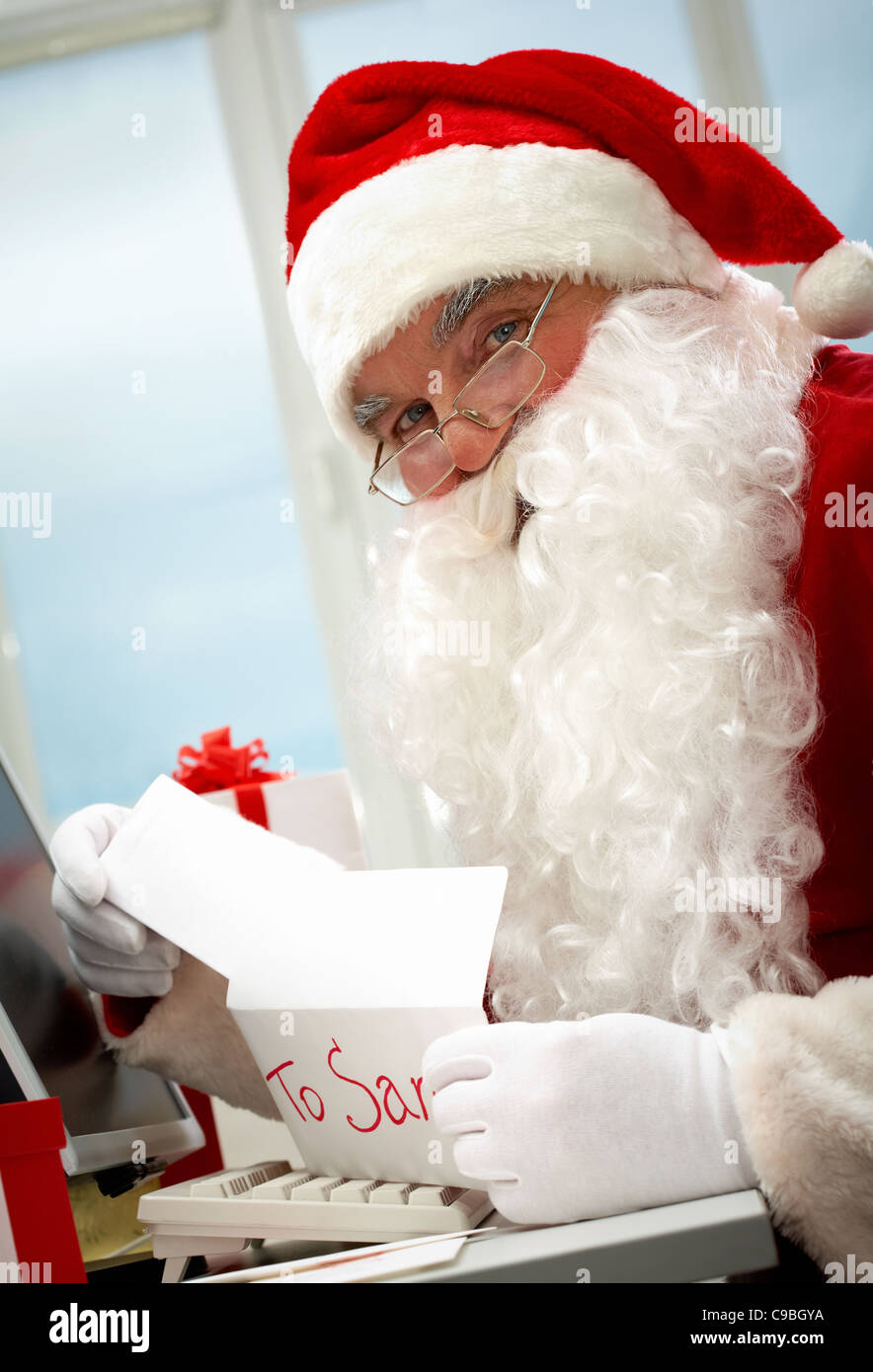 Santa holding Christmas letter and looking at camera Stock Photo - Alamy