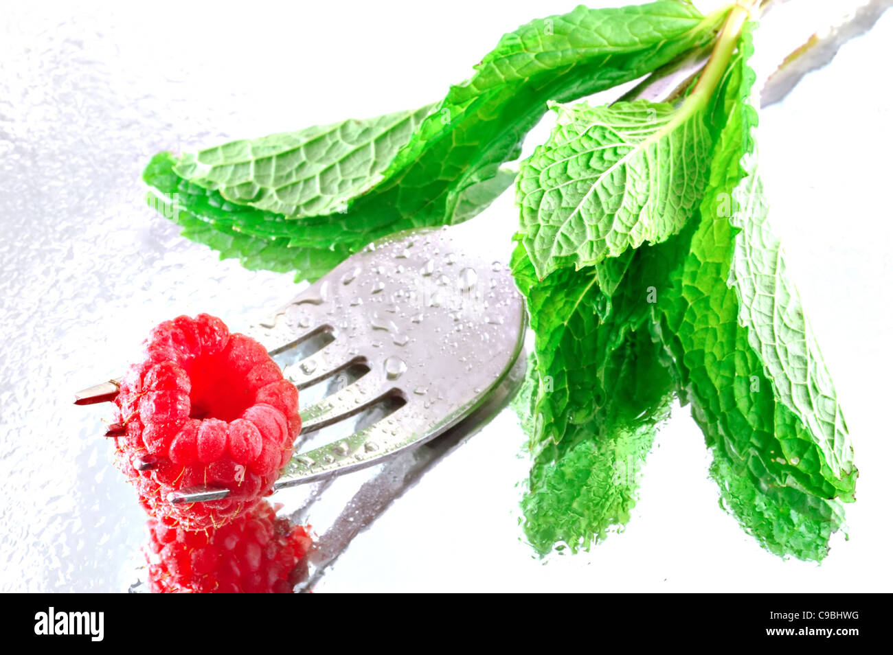 Fresh chilled raspberry with mint on a reflective background with a ...