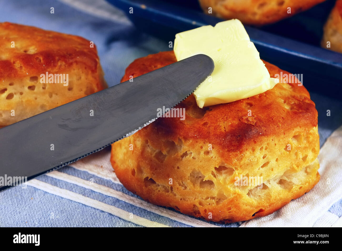 Buttering a homemade buttermilk biscuit in a vintage kitchen Stock ...
