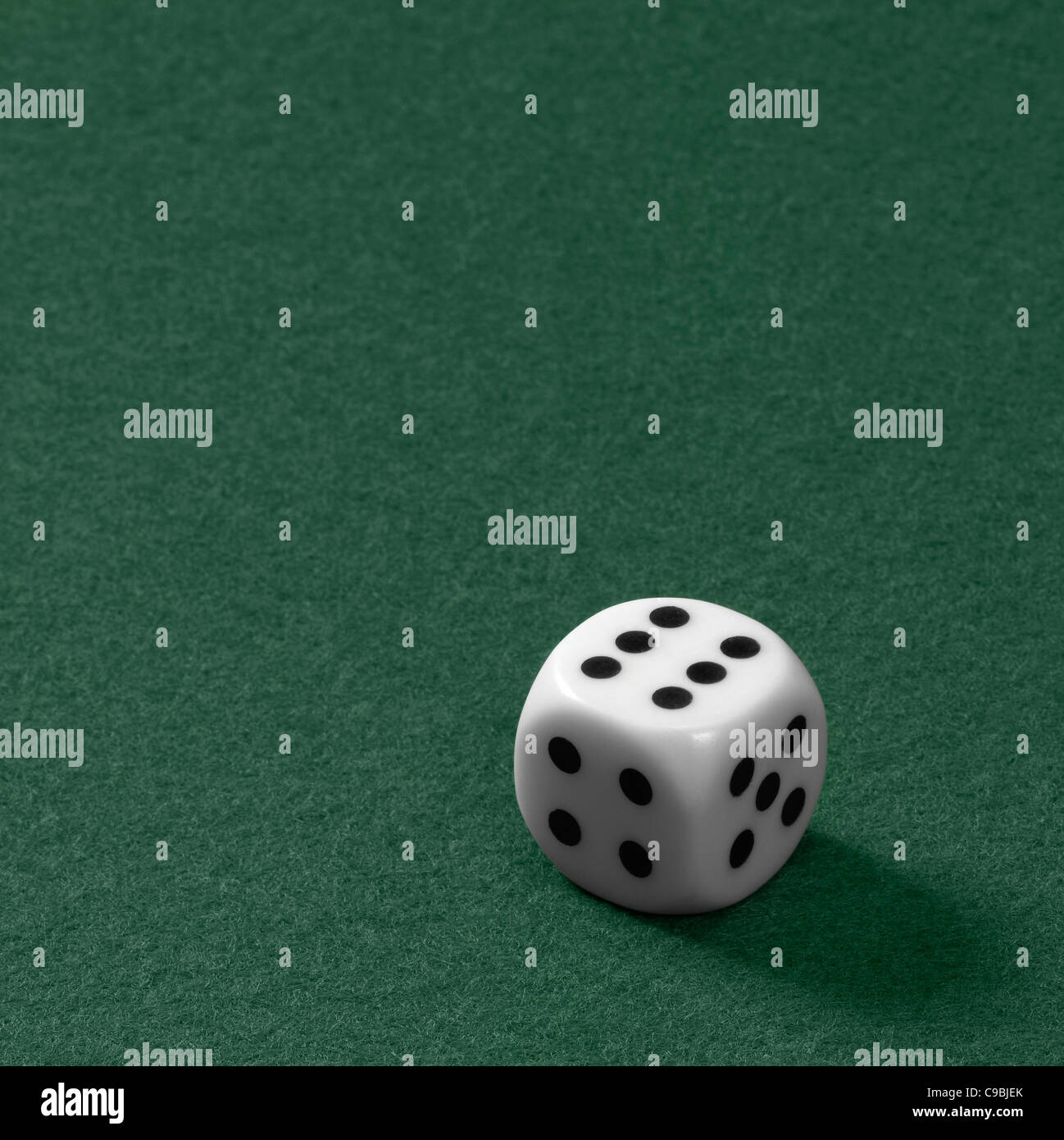symbolic gambling theme with a die on green felt background Stock Photo ...
