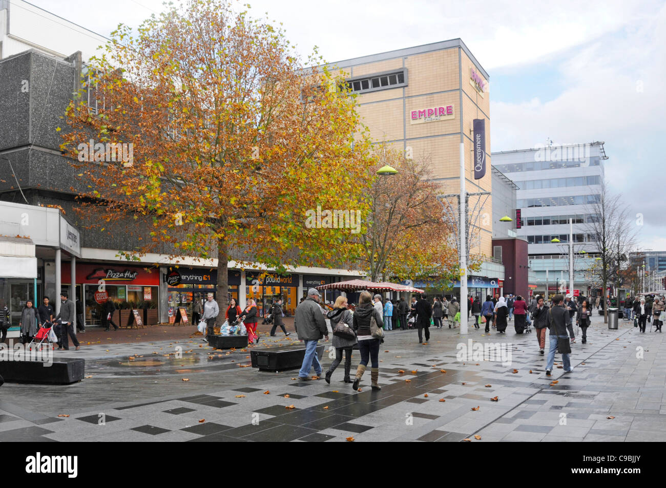 Autumn street scene people walking along town centre retail shopping ...