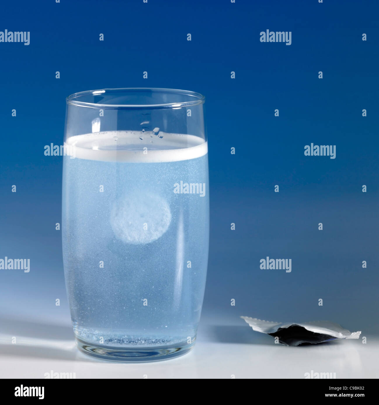 dissolving fizzy tablet floating in a glass of water. Studio ...