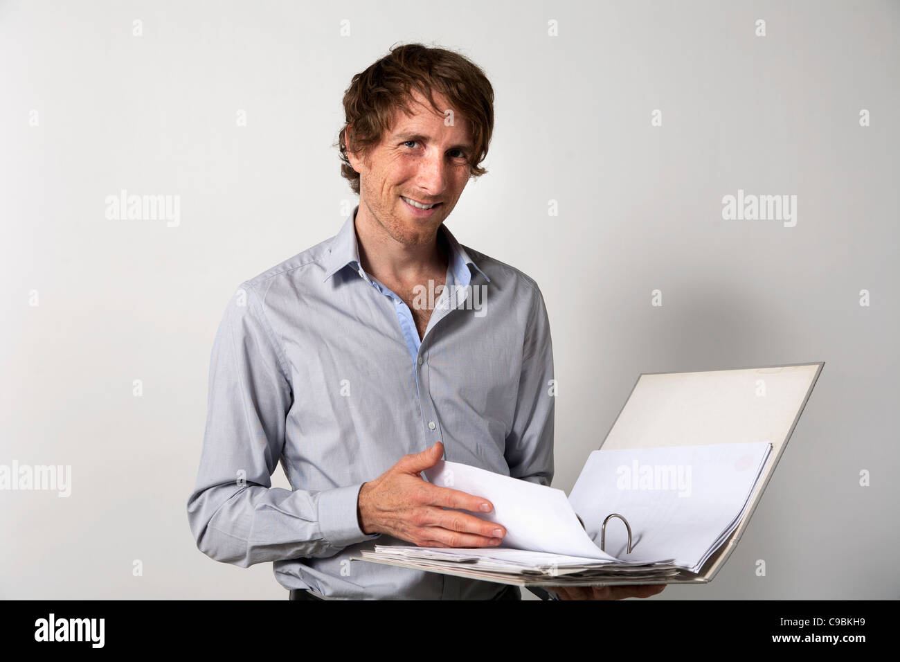 Man searching information from file, smiling, portrait Stock Photo - Alamy