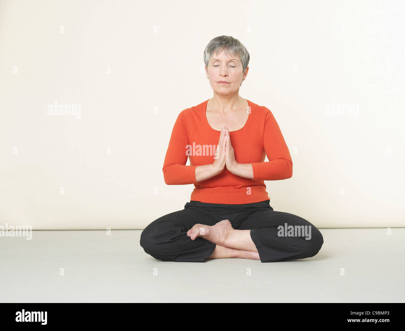 Senior woman sitting in prayer position Stock Photo - Alamy