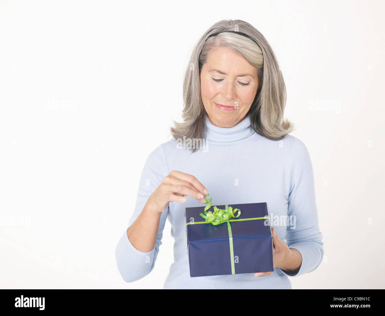 Senior woman opening gift box, smiling Stock Photo - Alamy