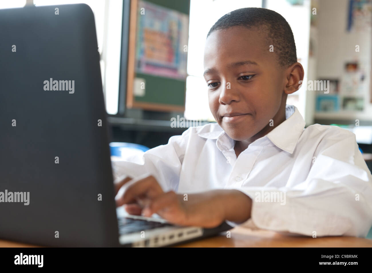 Boy typing on laptop in classroom, Johannesburg, Gauteng Province ...