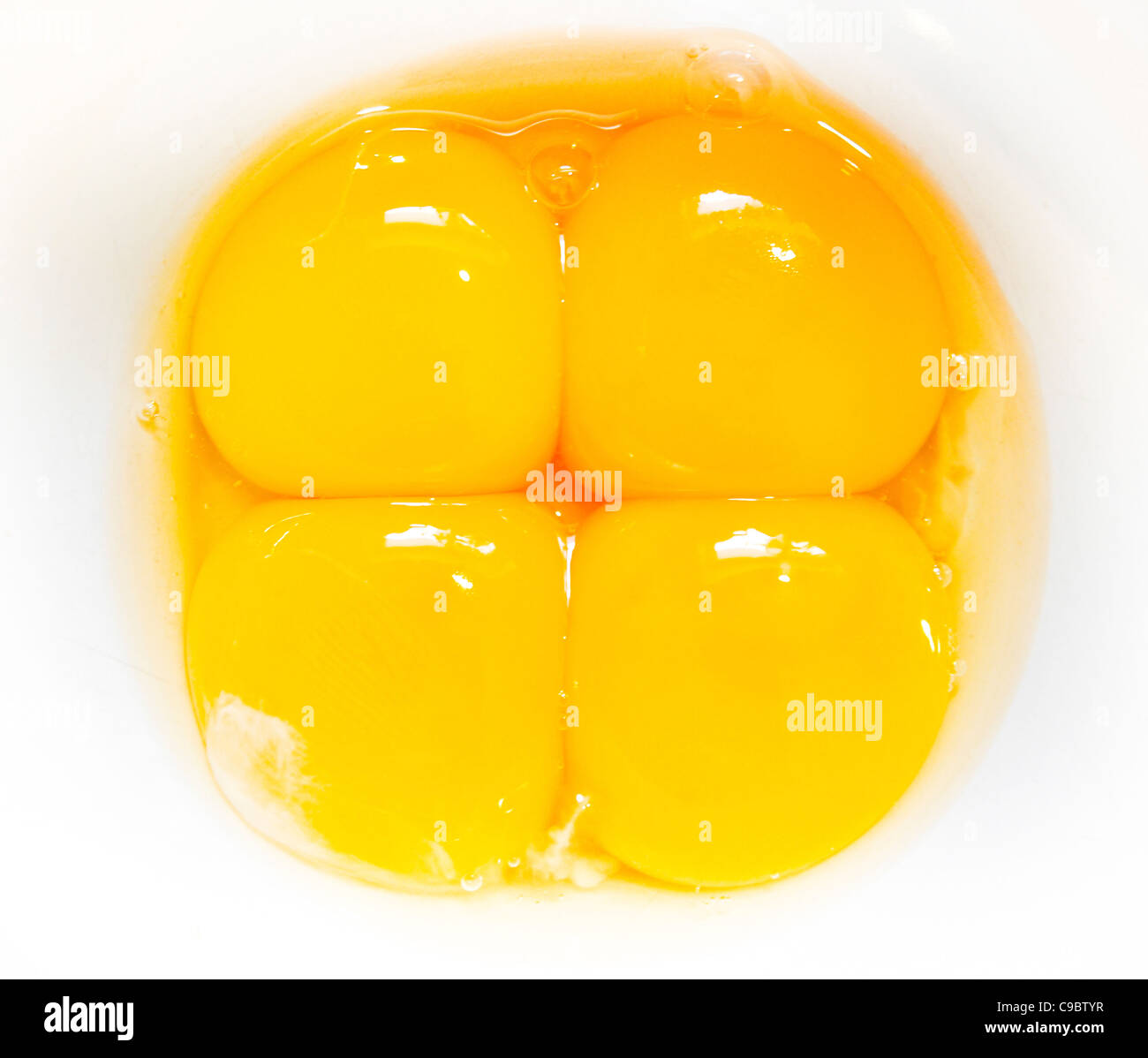 four raw egg yolks in a bowl Stock Photo - Alamy