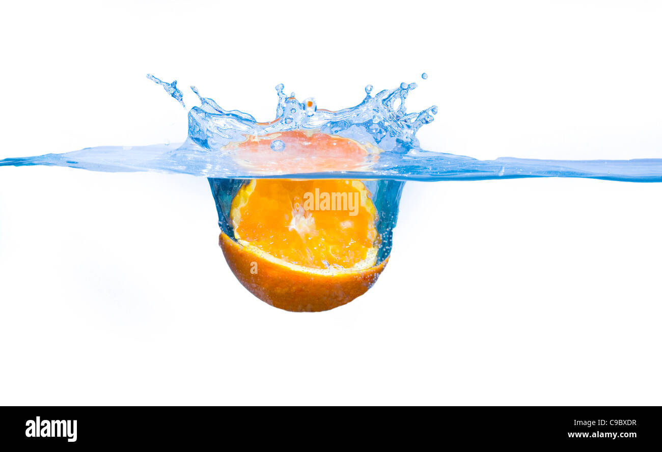 Fruit splashing into water isolated on white background Stock Photo - Alamy