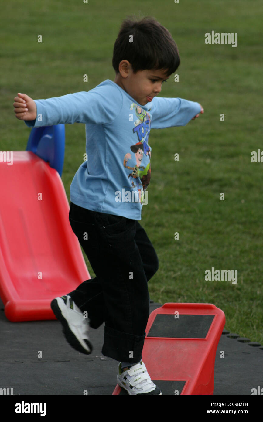 Young boy balancing on rocker at village fair Stock Photo - Alamy