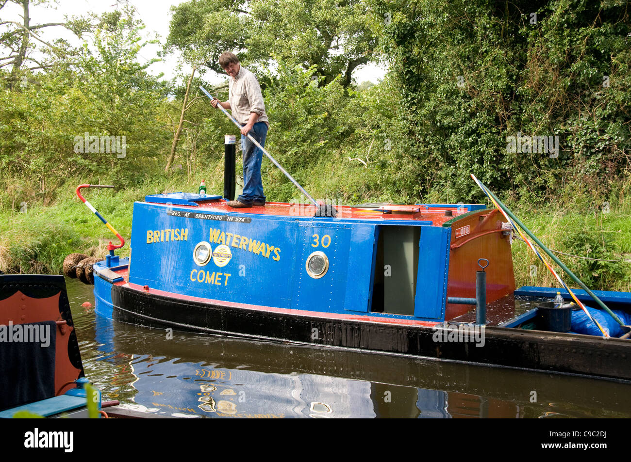 A man mopping the roof of his traditional working narrowboat Stock ...