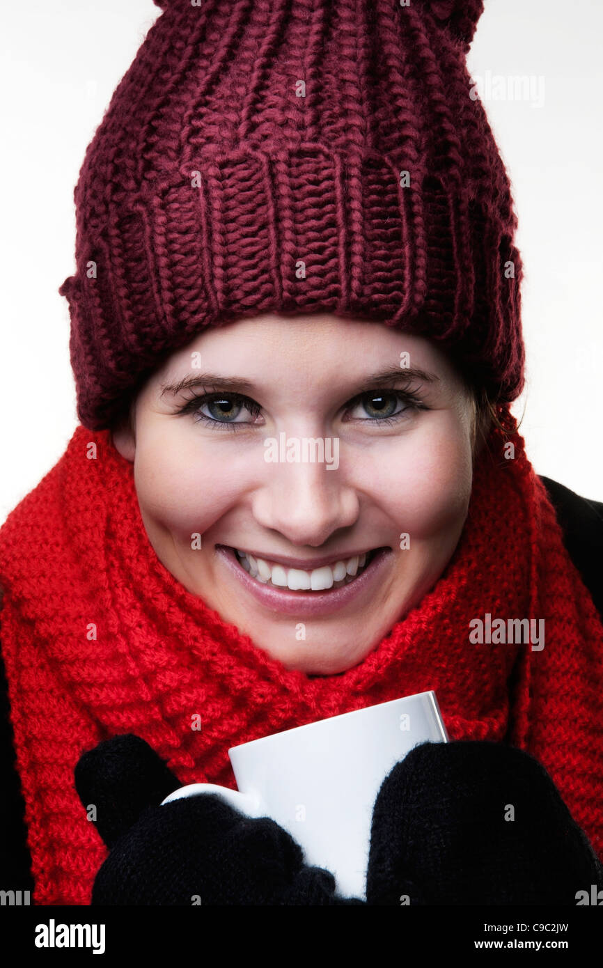 woman looking cold in winter clothes drinking a hot drink to keep warm ...