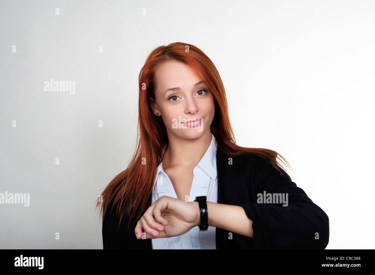 woman in a suit looking at her watch Stock Photo - Alamy