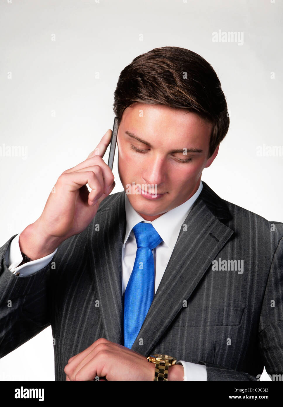 man on his mobile phone looking at his watch Stock Photo - Alamy