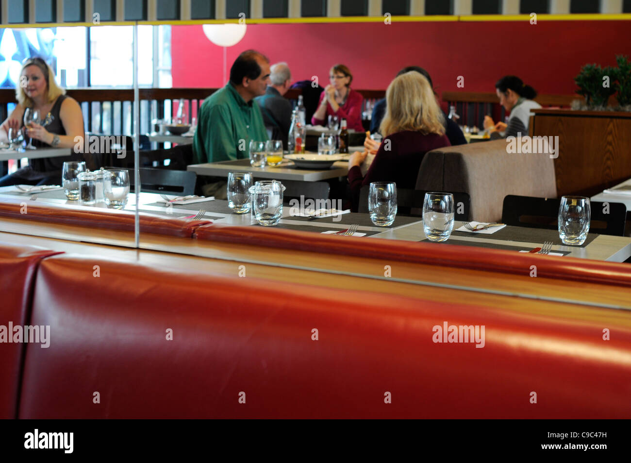 Restaurant interior with diners viewed reflected in a wall length ...