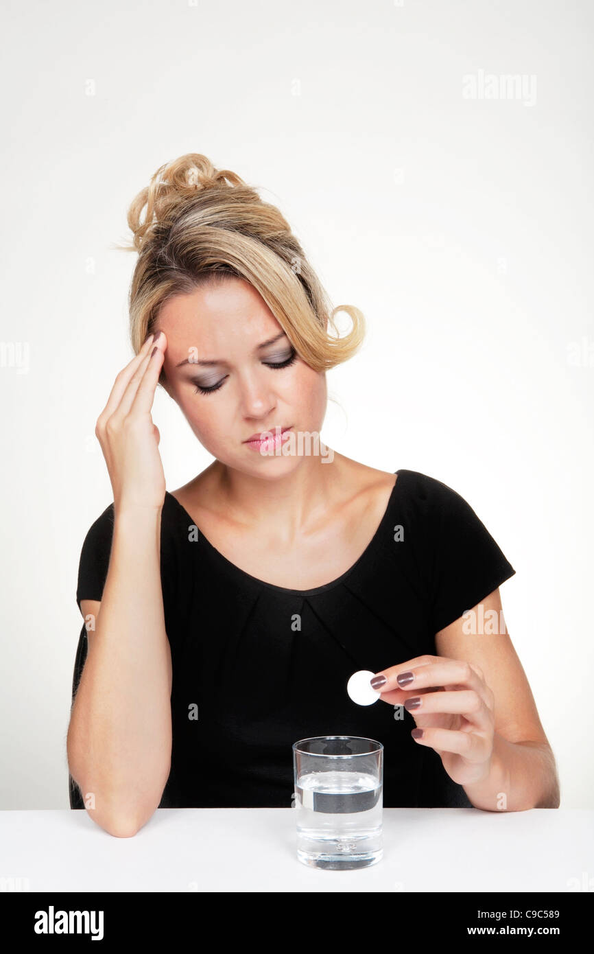 woman at her desk about to take a soluble tablet in water Stock Photo ...