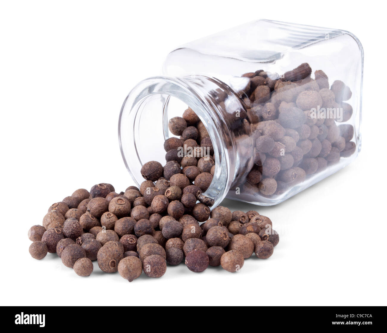 Pimento is scattered on a white background from glass bottle Stock ...