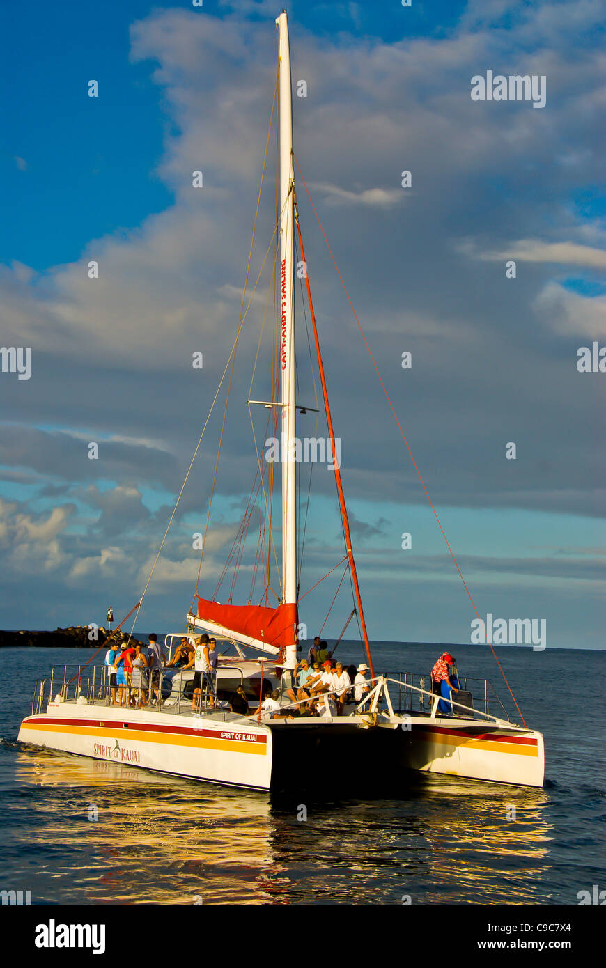 Red and white sailing catamaran with large group of tourists hi-res ...