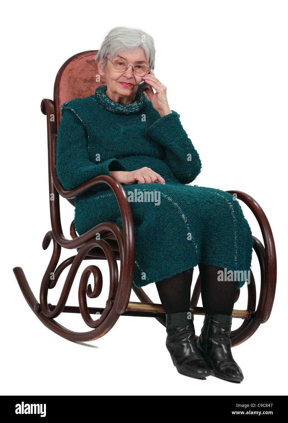 Image of an old woman sitting in a rocker and using a mobile phone ...