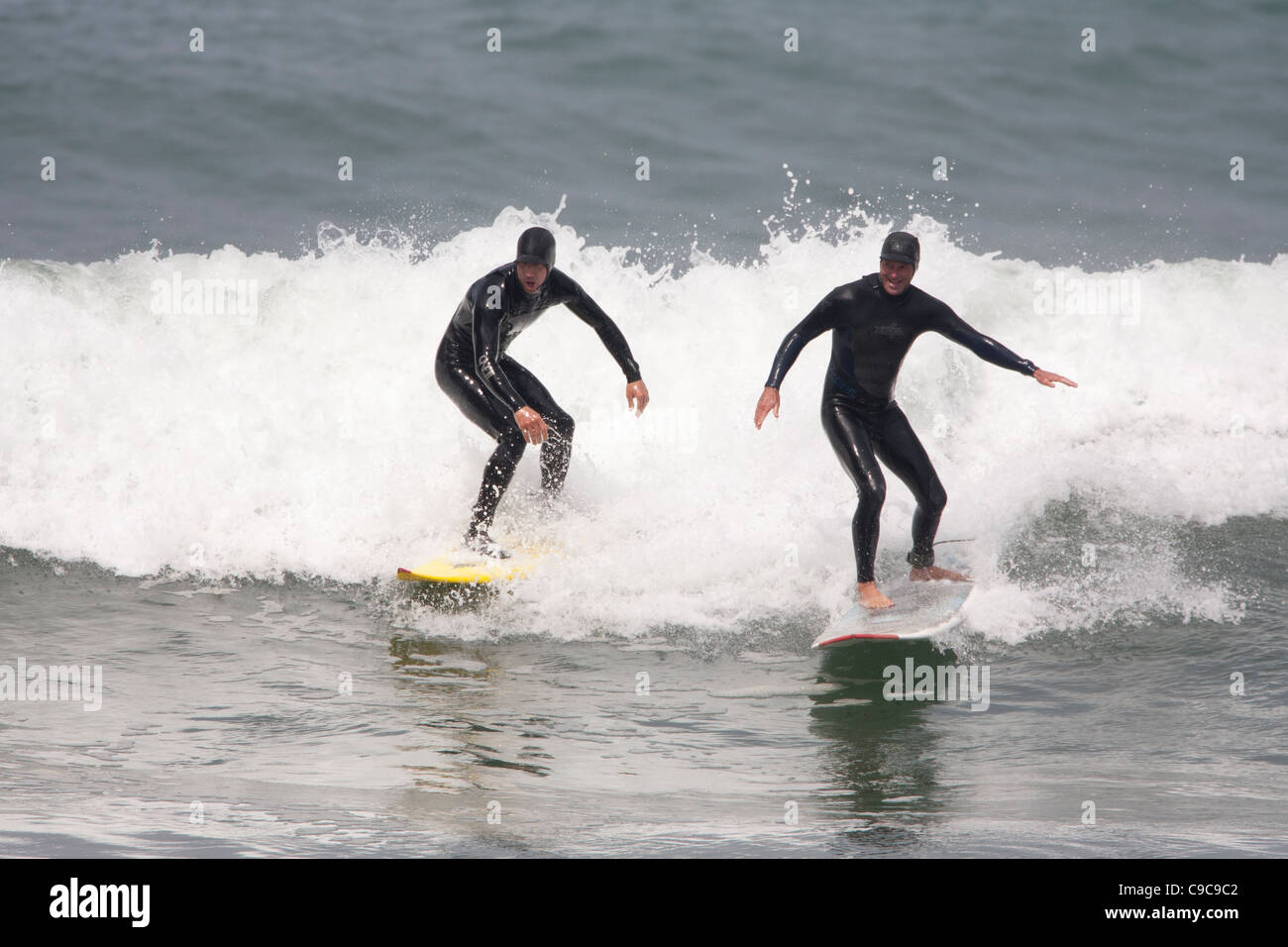 Two Surfers side by side on breaking wave Stock Photo - Alamy