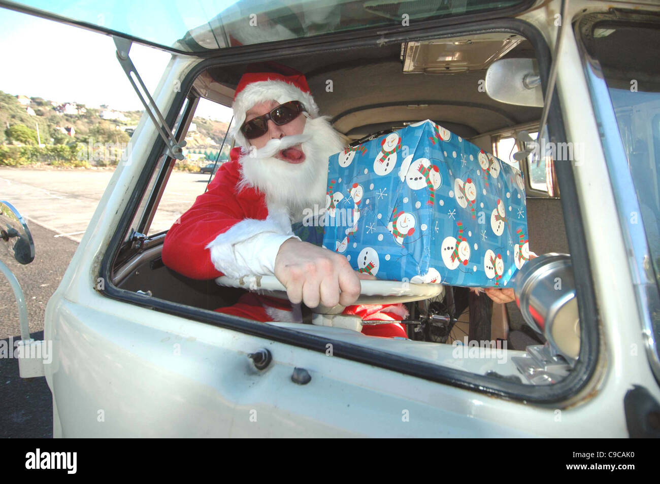 SANTA CLAUS WITH PRESENT LOOKING THROUGH WINDOW OF SPLIT SCREEN CAMPER ...