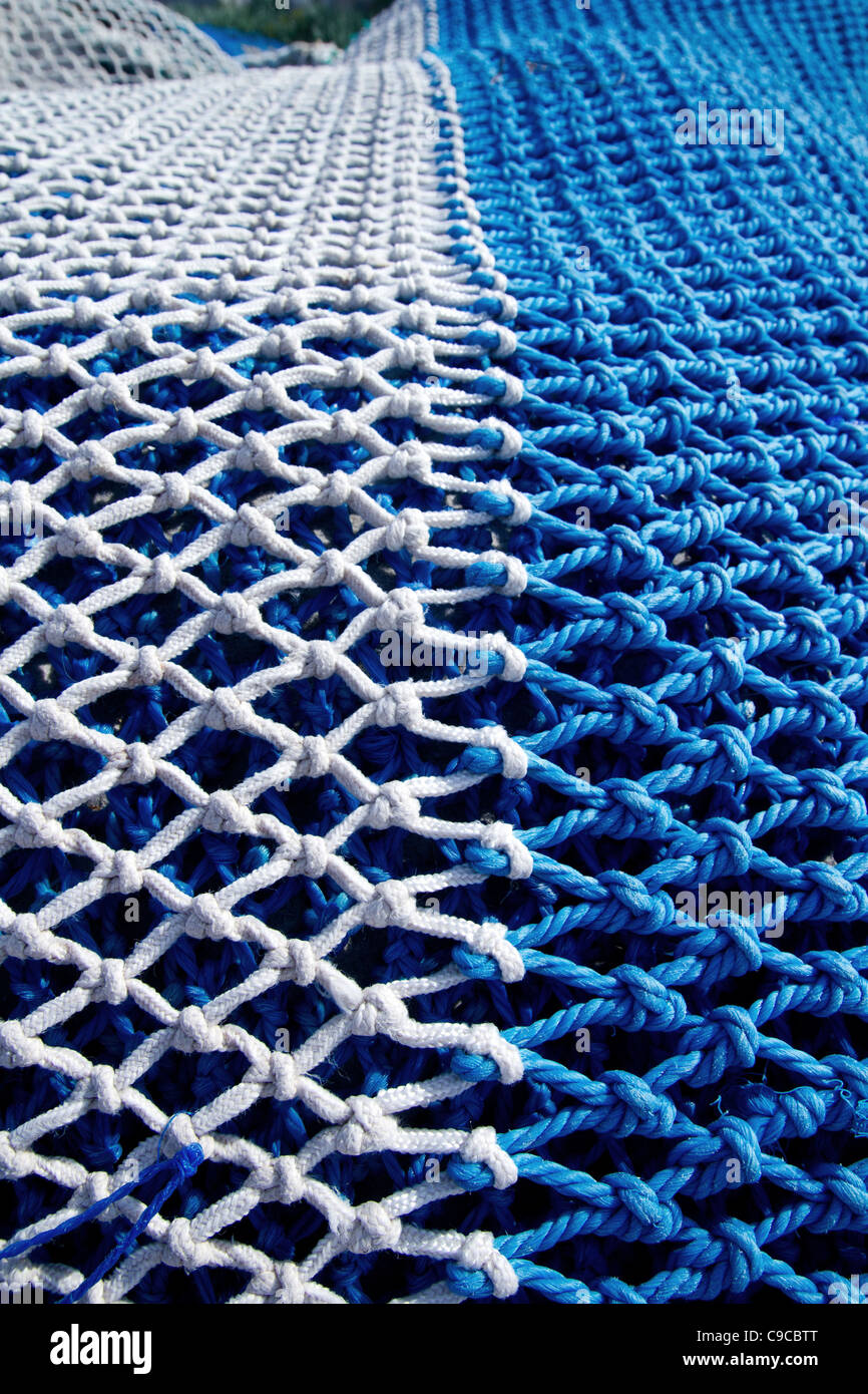 blue and white fishing nets with rope knots for trawling boats Stock ...