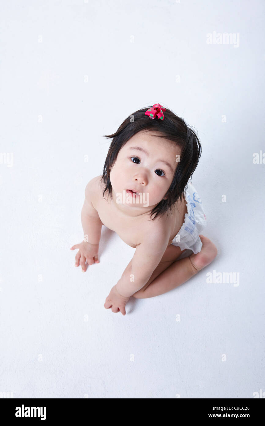 Baby girl in nappy with red ribbon Stock Photo - Alamy