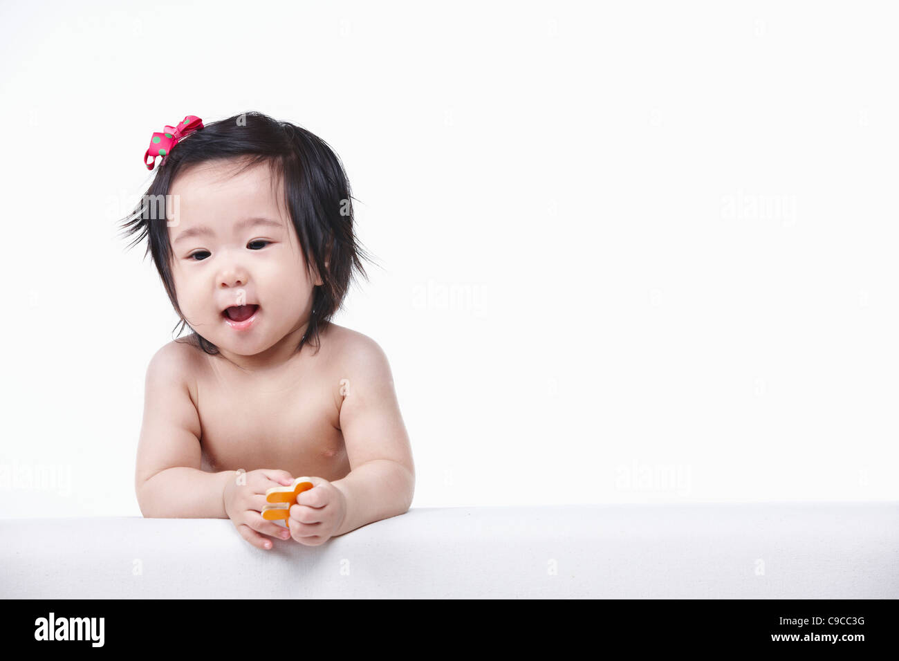 Baby girl with red ribbon Stock Photo - Alamy