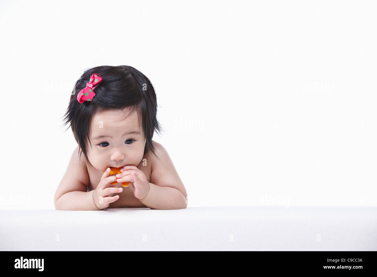Baby girl with red ribbon Stock Photo - Alamy