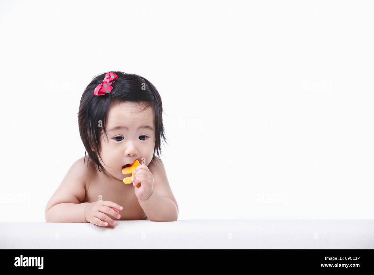 Baby girl with red ribbon Stock Photo - Alamy