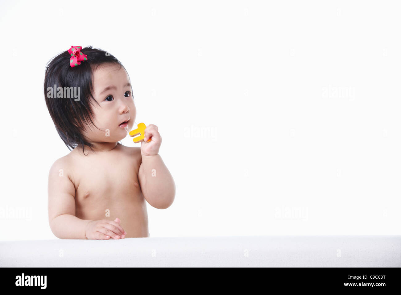 Baby girl with red ribbon Stock Photo - Alamy