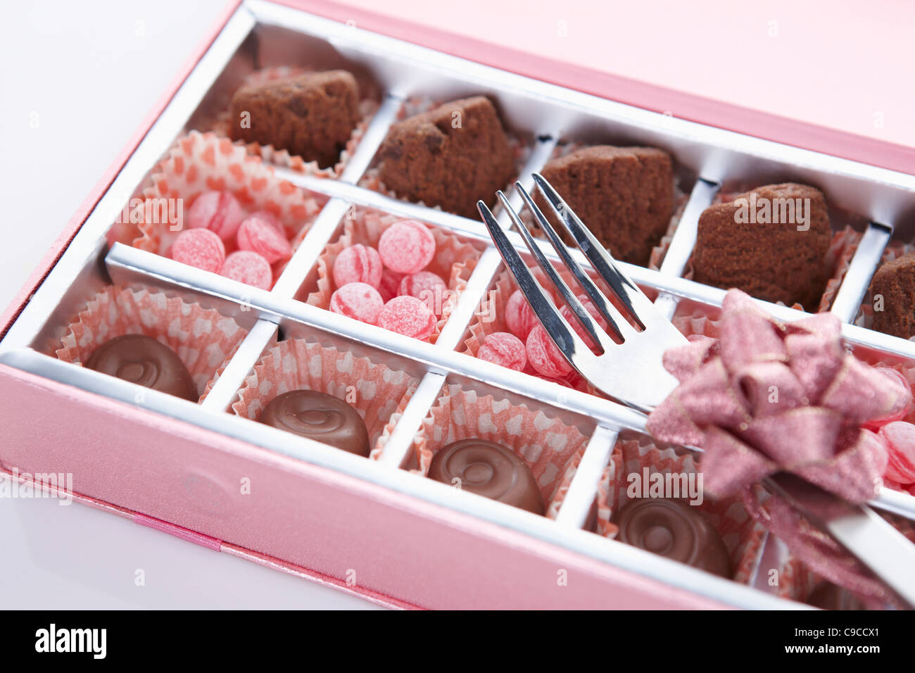 A box of sweets and a folk with ribbon Stock Photo - Alamy