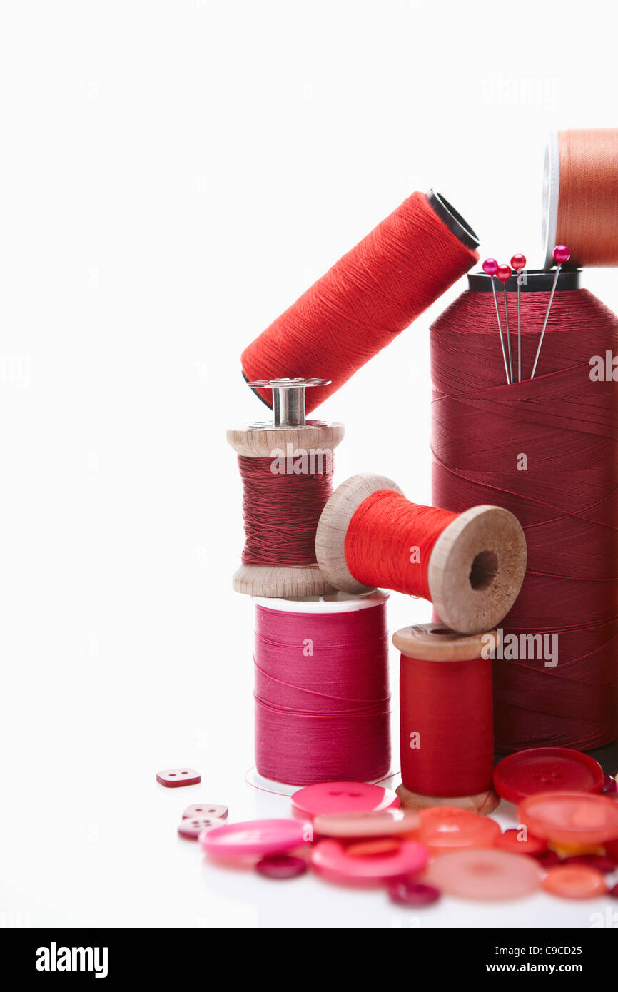 Various reel of threads and sewing tools in red Stock Photo - Alamy