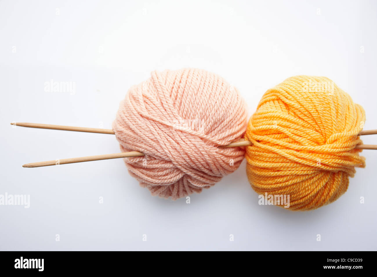 Knitting yarn balls in pink and orange and needles Stock Photo - Alamy