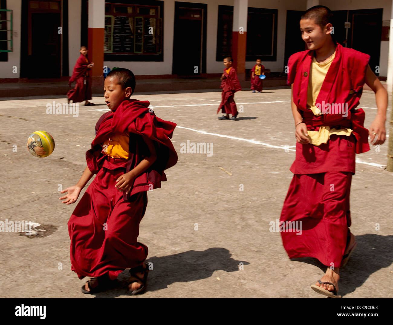 India, South Asia, Sikkim, Buddhist student monks playing soccer at a ...