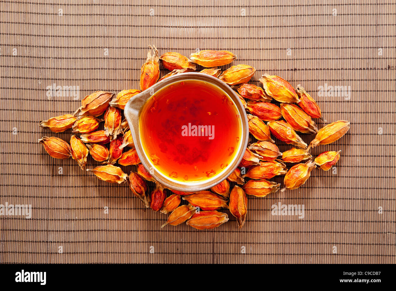 Cup of gardenia tea and its seeds Stock Photo - Alamy