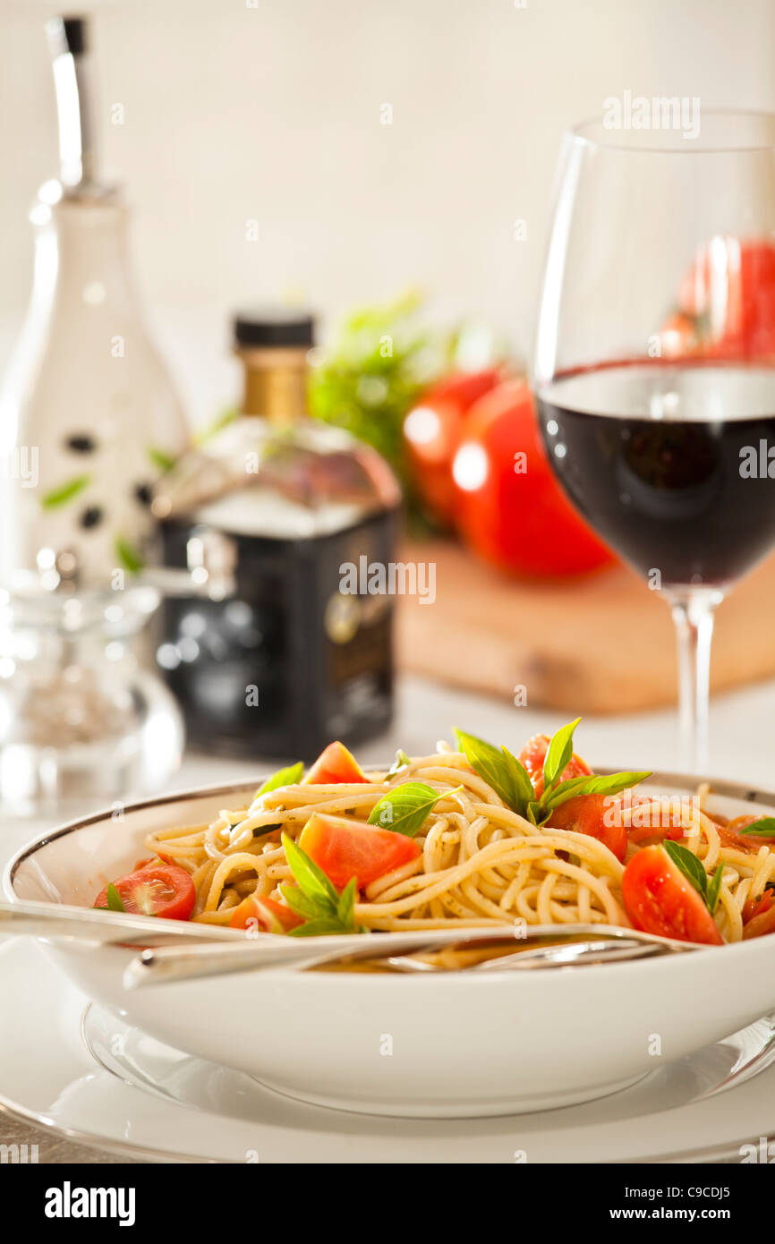 Photograph of a tomato and basil pasta dish set for dinner Stock Photo ...