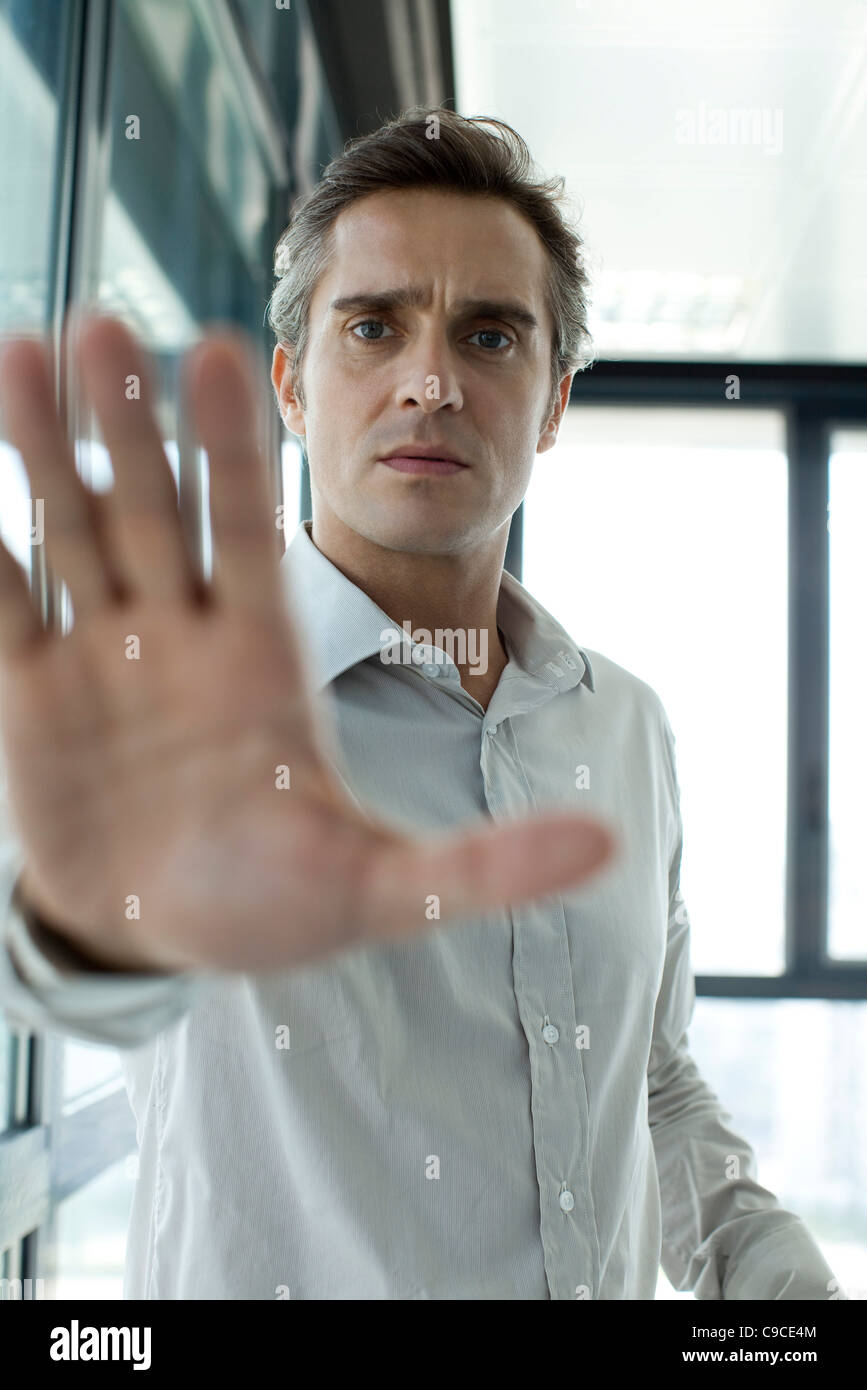 Man holding hand up in front of camera, backlit Stock Photo - Alamy