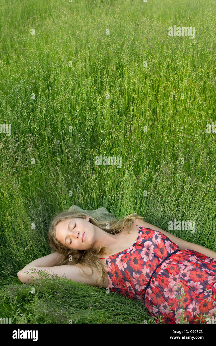 Young woman napping in tall grass Stock Photo - Alamy