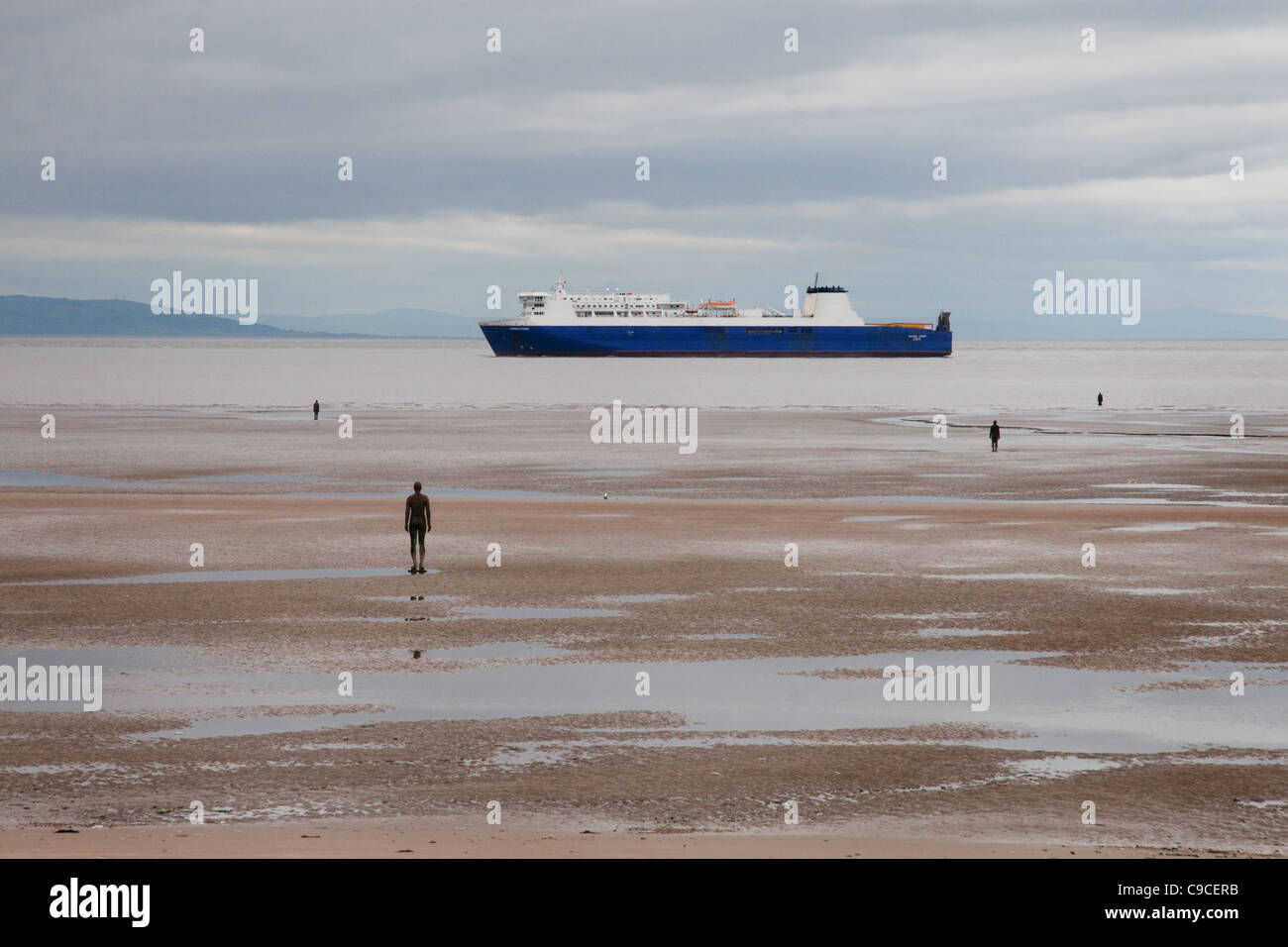 A container ship heading for port past figures from Anthony Gormley's ...