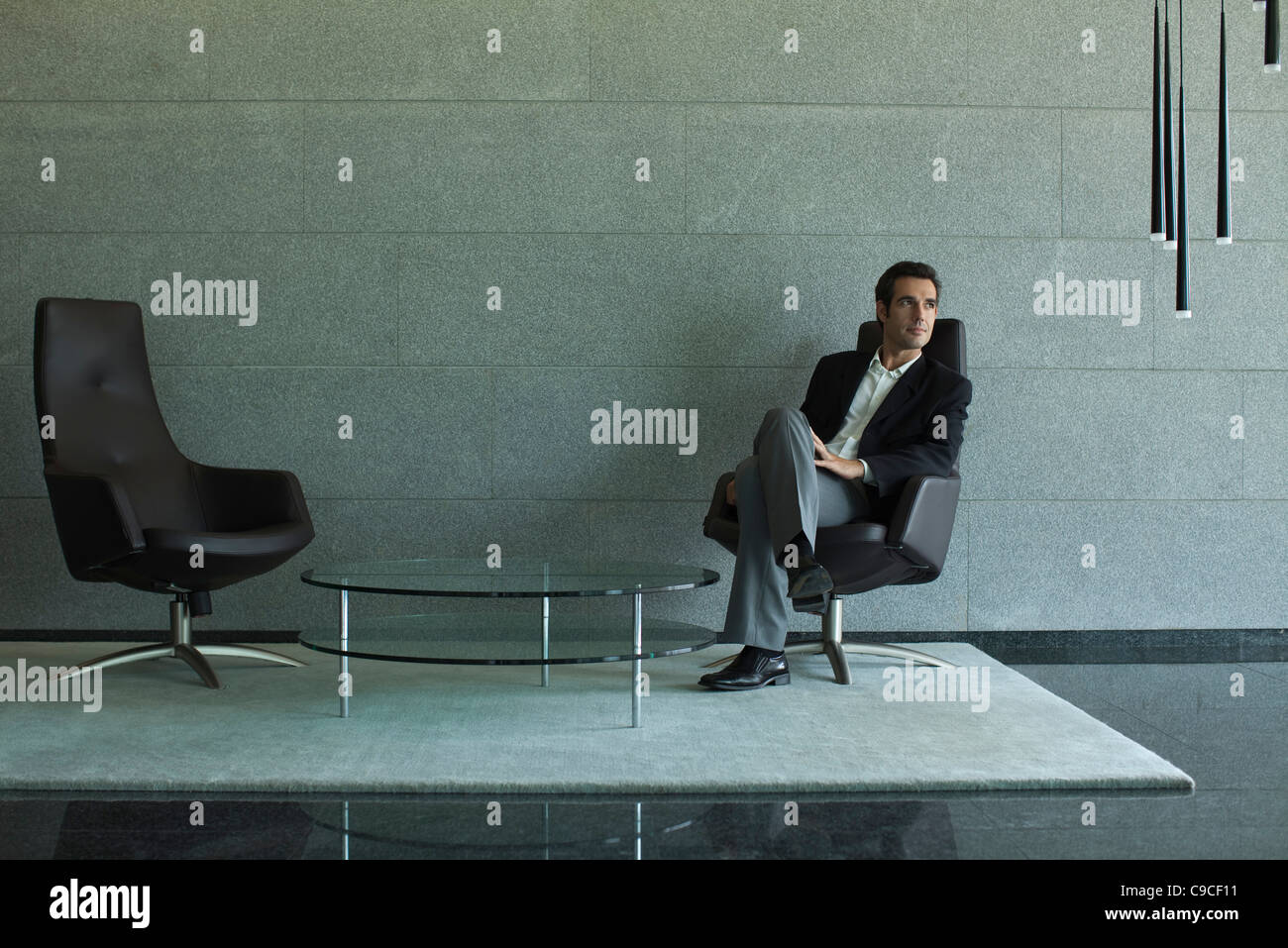 Executive sitting in lobby Stock Photo - Alamy