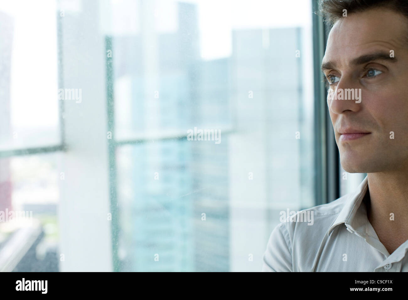 Man looking out of window Stock Photo - Alamy