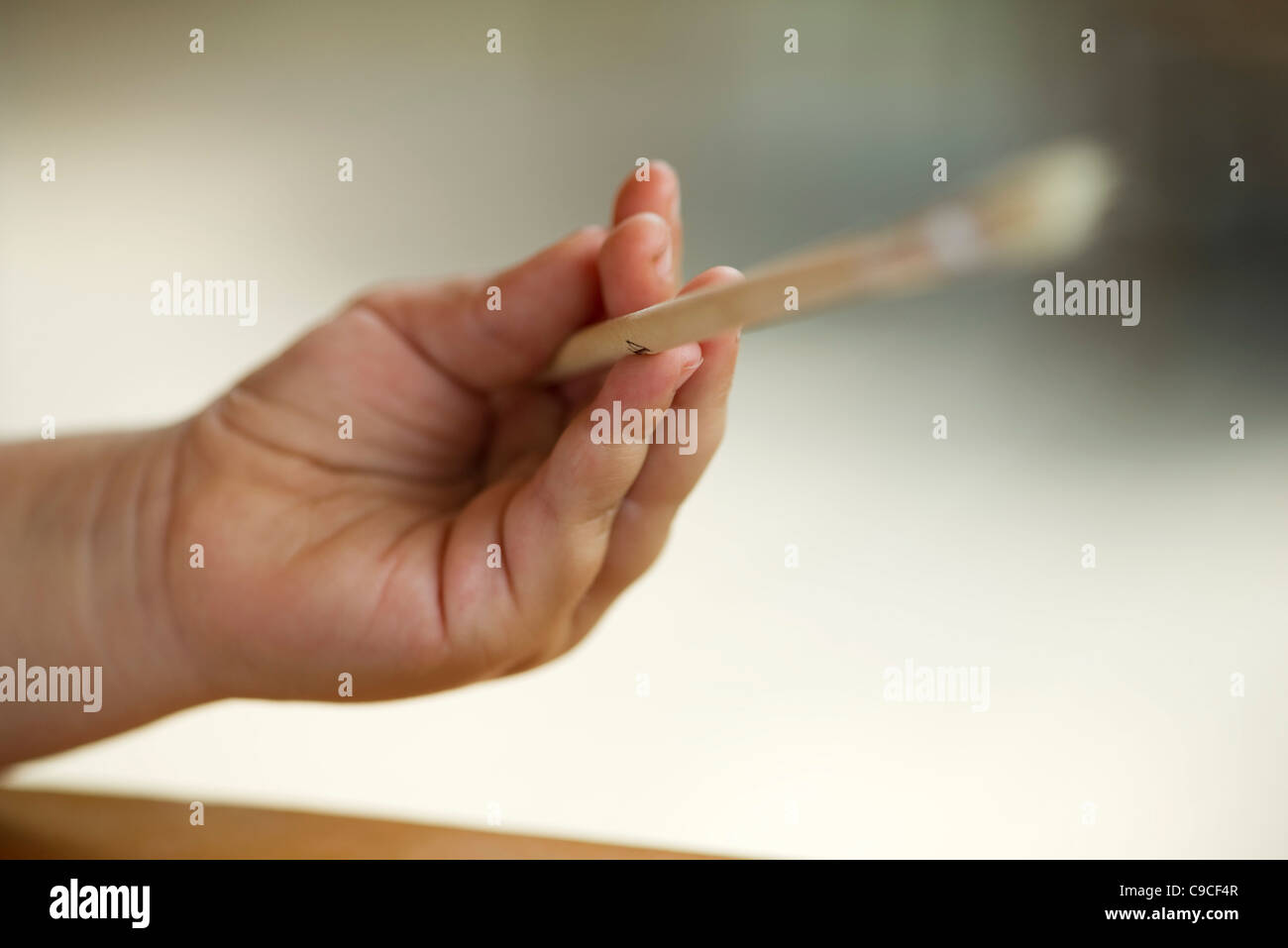 Child's hand holding paintbrush Stock Photo - Alamy