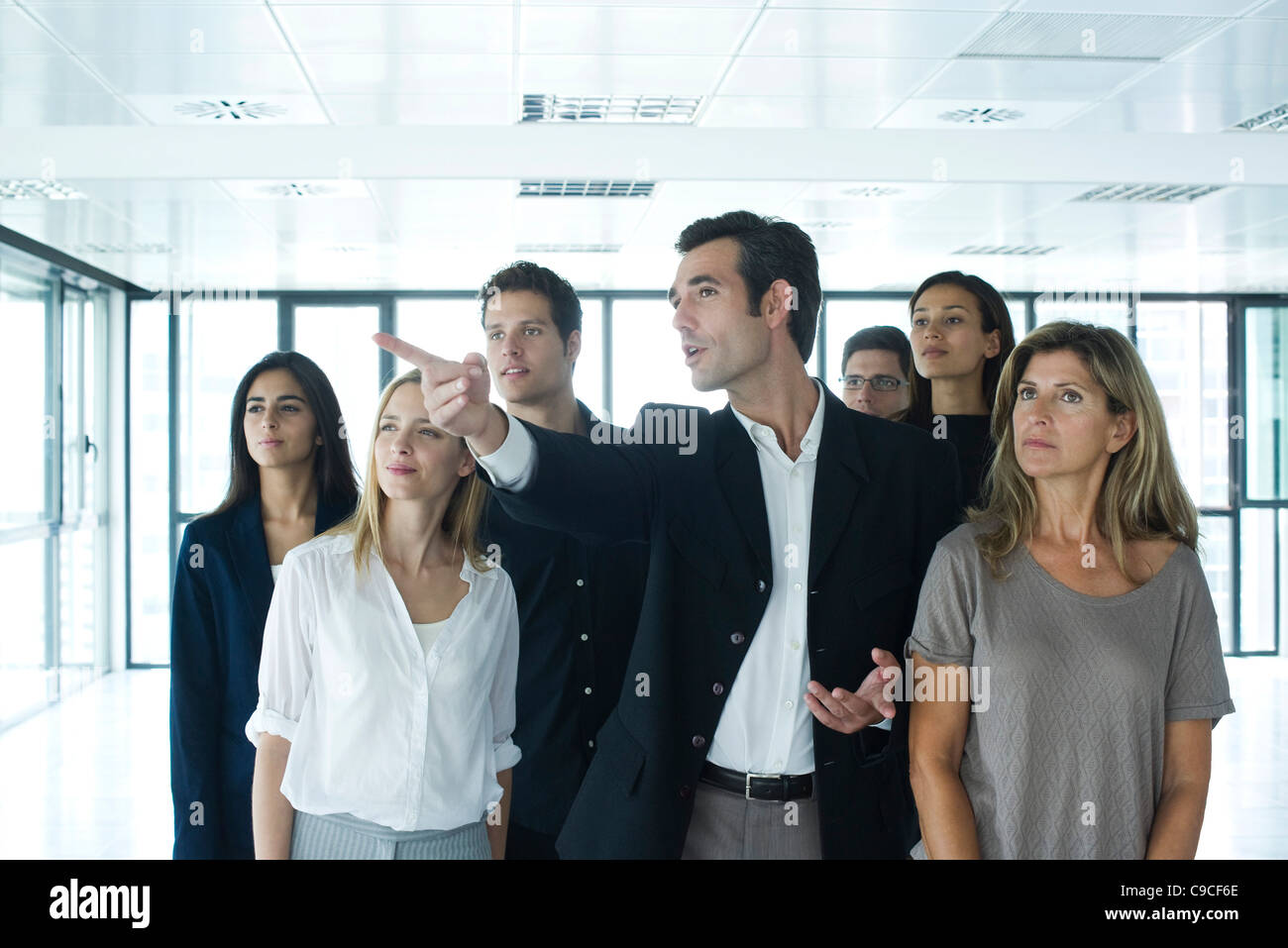 Real estate agent giving tour to business people in new office Stock ...
