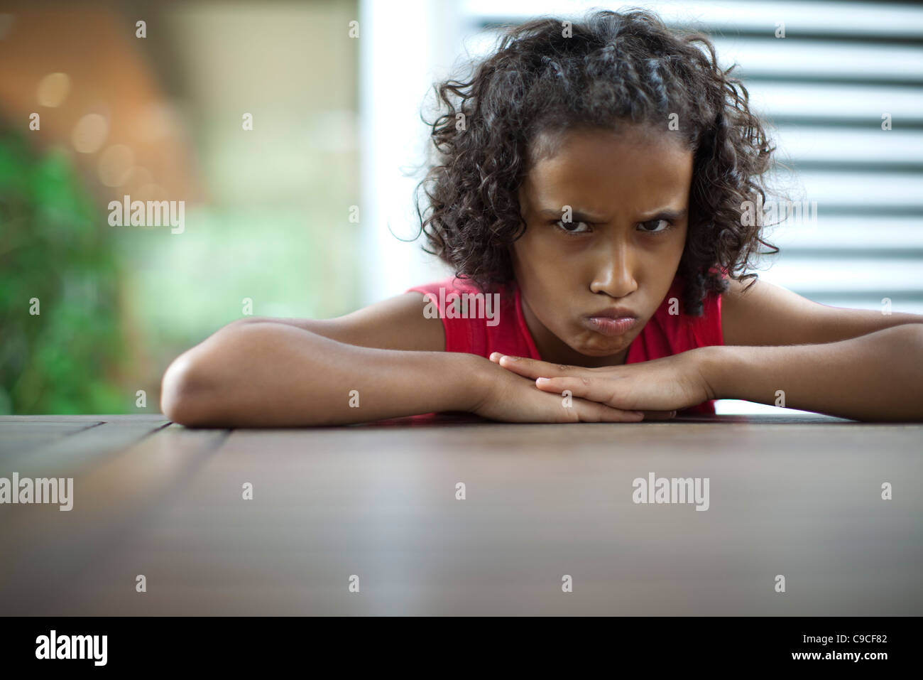 Sulky girl scowling at camera Stock Photo - Alamy